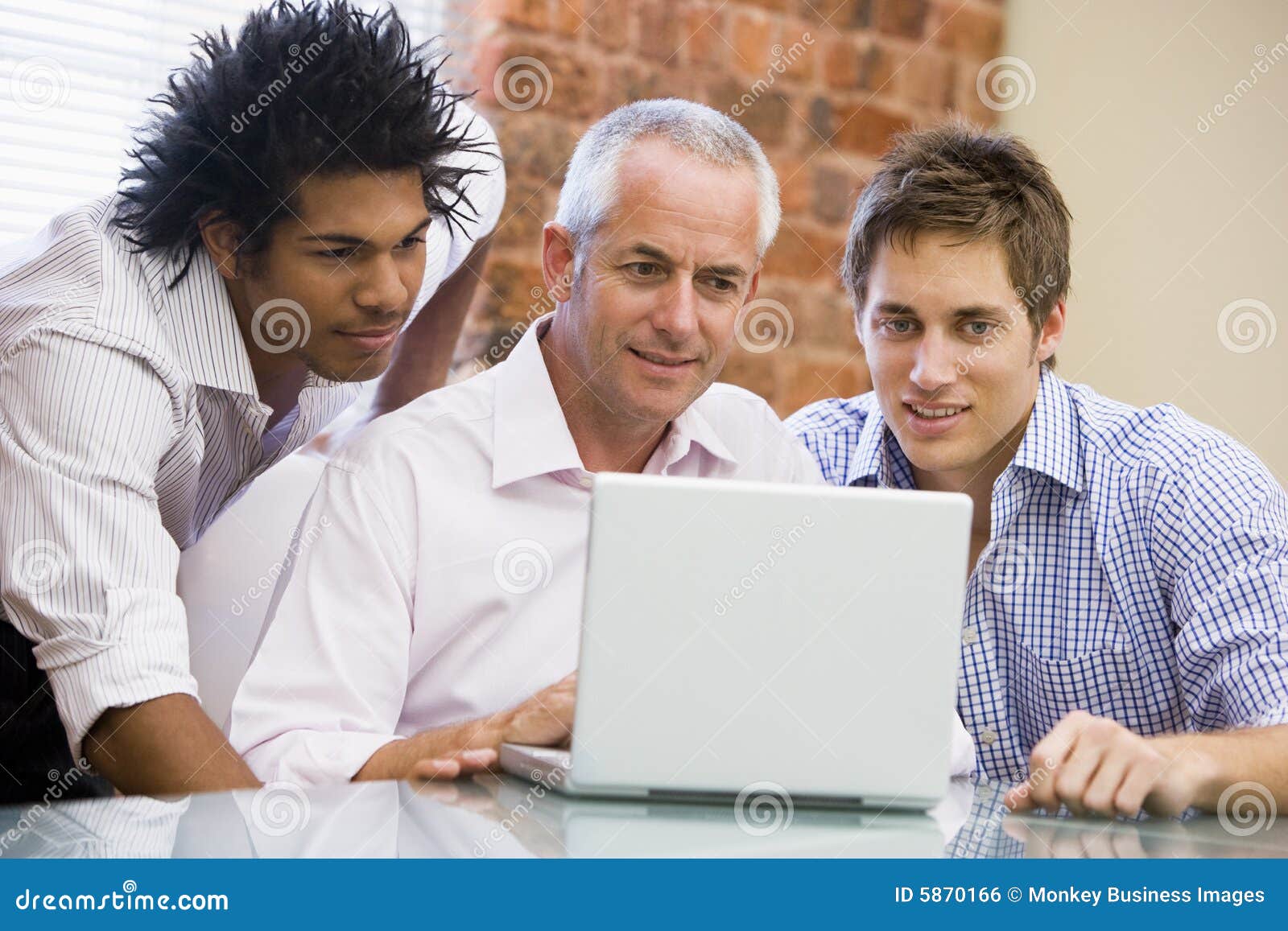 Three Businessmen in Office Looking at Laptop Stock Photo - Image of ...