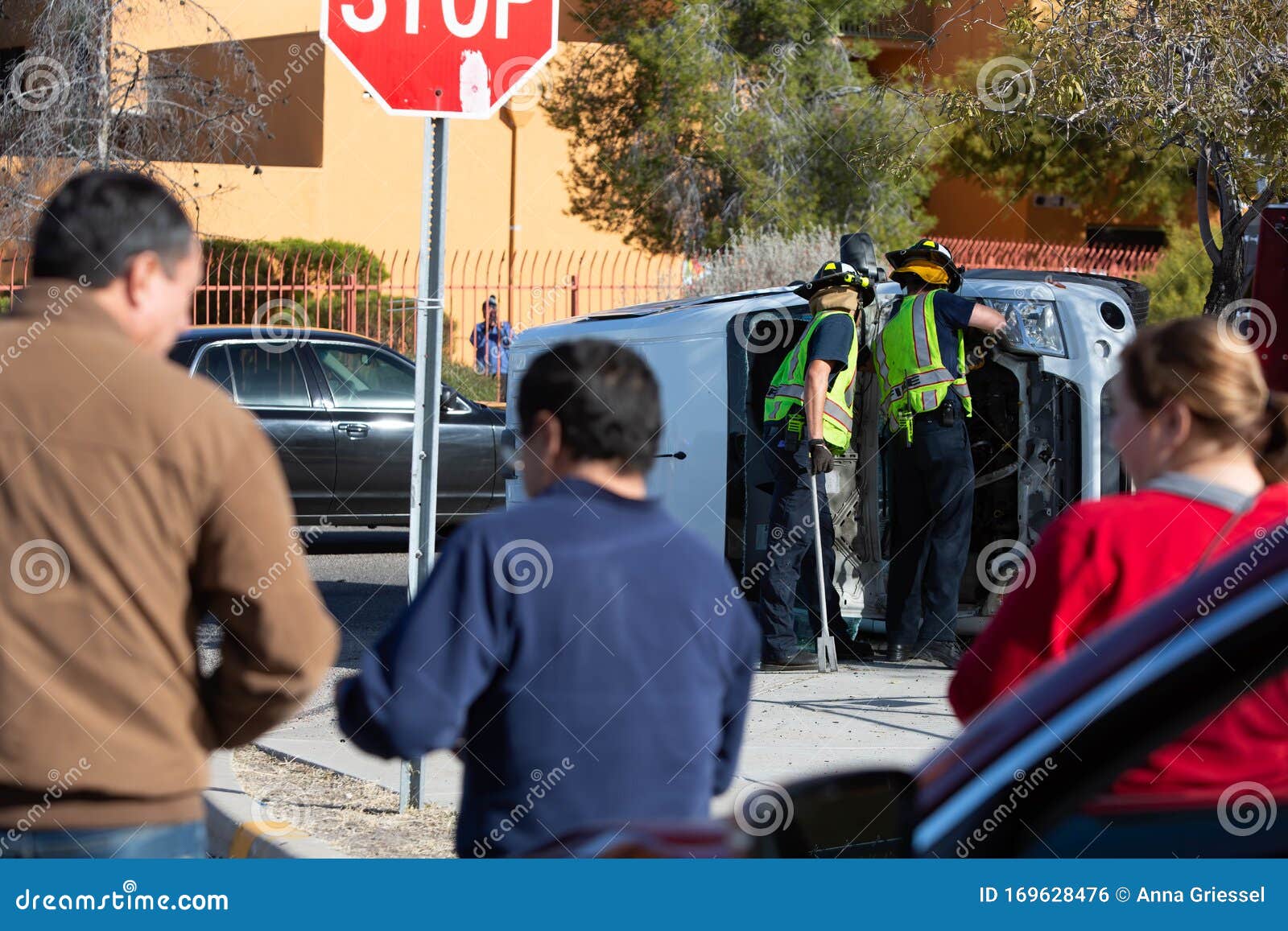 Three Bystanders Watch Emergency Responders Clearing a Crashed Minivan ...