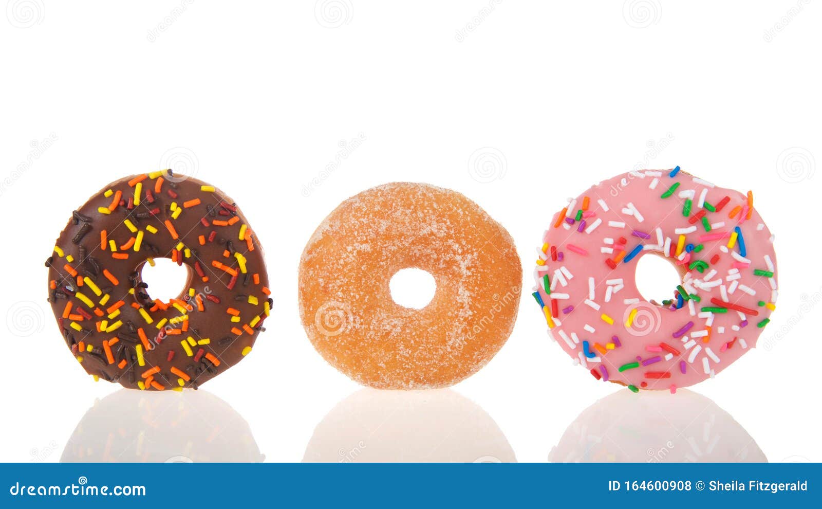 Three Cake Donuts in a Row with Reflection on Table in Front of Them ...