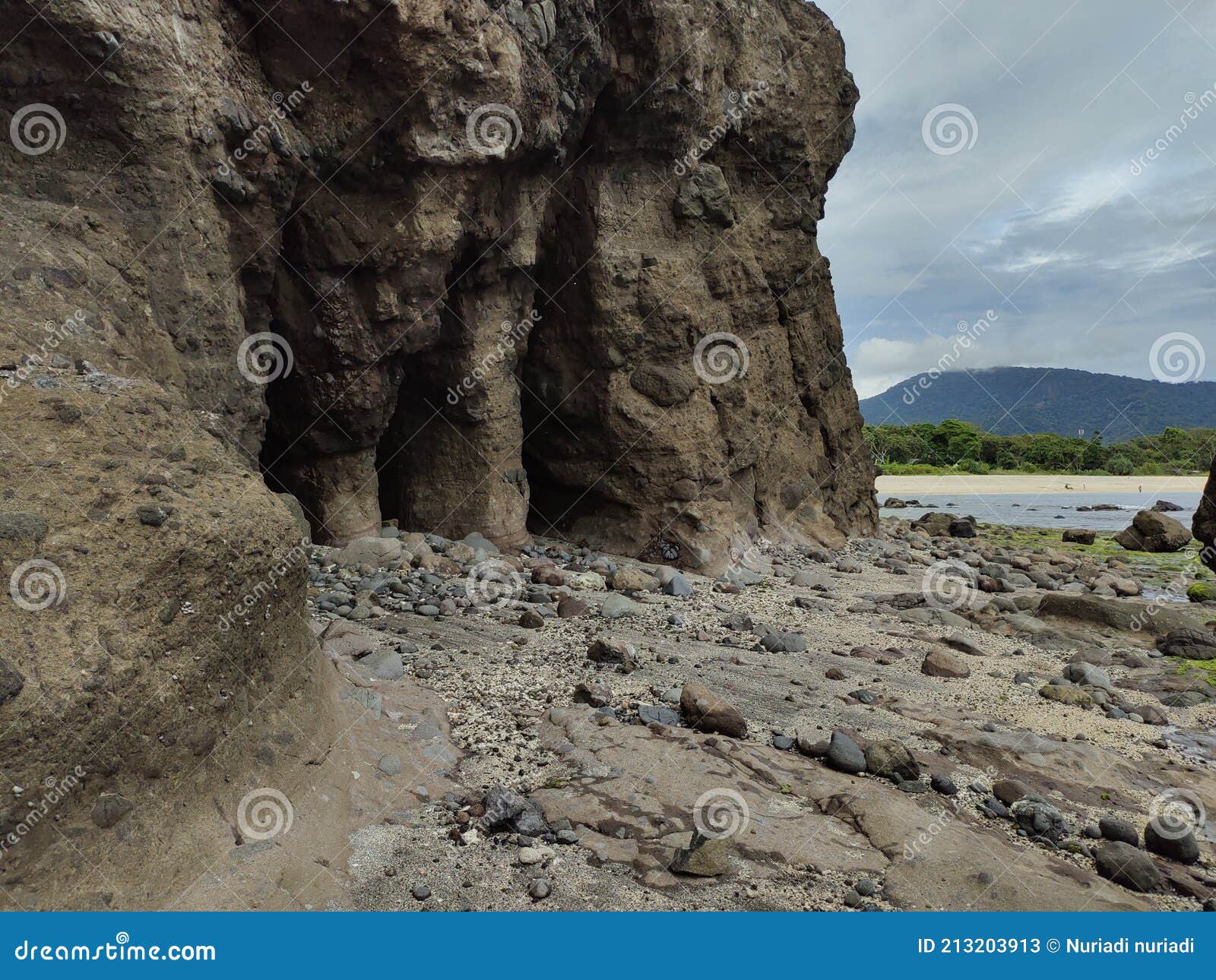 Three Caves in a Rock Wall by the Beach Stock Image - Image of three ...
