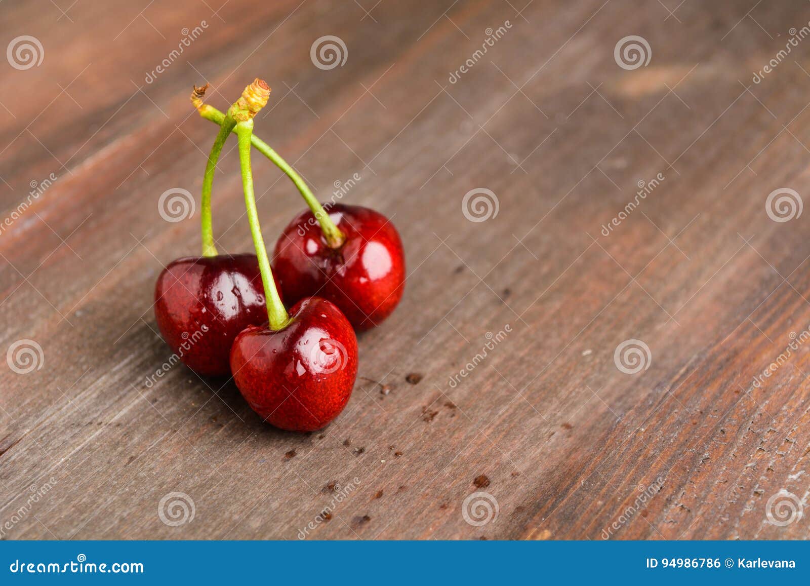Three Cherry on Brown Wooden Table with Copy Space Stock Photo - Image ...