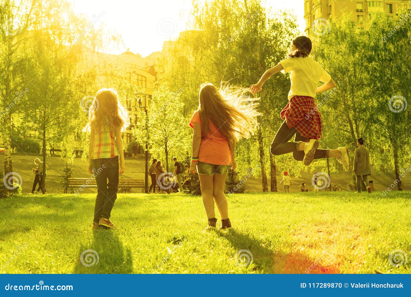 Three Children Girls at Sunset Jumping in the Park, Back View Stock ...