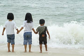 Three Children Playing with Waves Stock Photo - Image of waves, trio ...