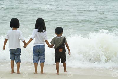 Three Children Playing with Waves Stock Photo - Image of waves, trio ...
