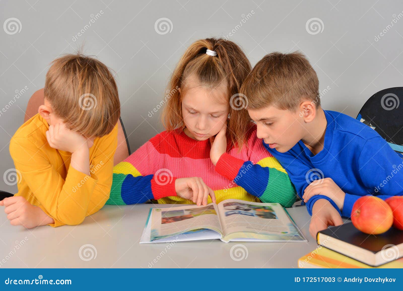 Three Children Read a Book and Do Their Homework Assigned at School ...