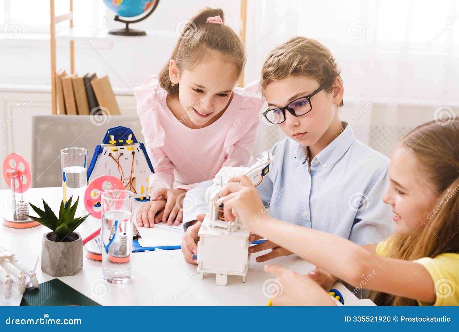 Three Children Working on Science Project in Classroom Stock Photo ...