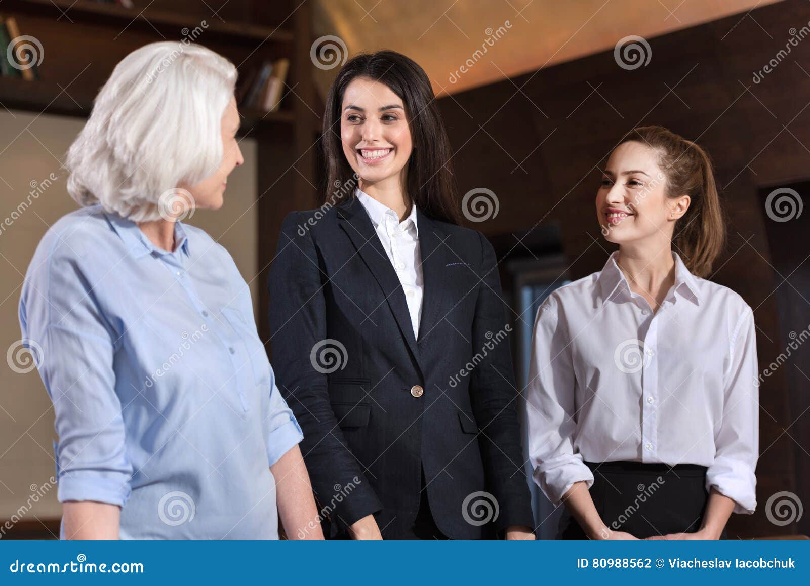 Three Colleagues Communicating Happily in an Office Stock Photo - Image ...