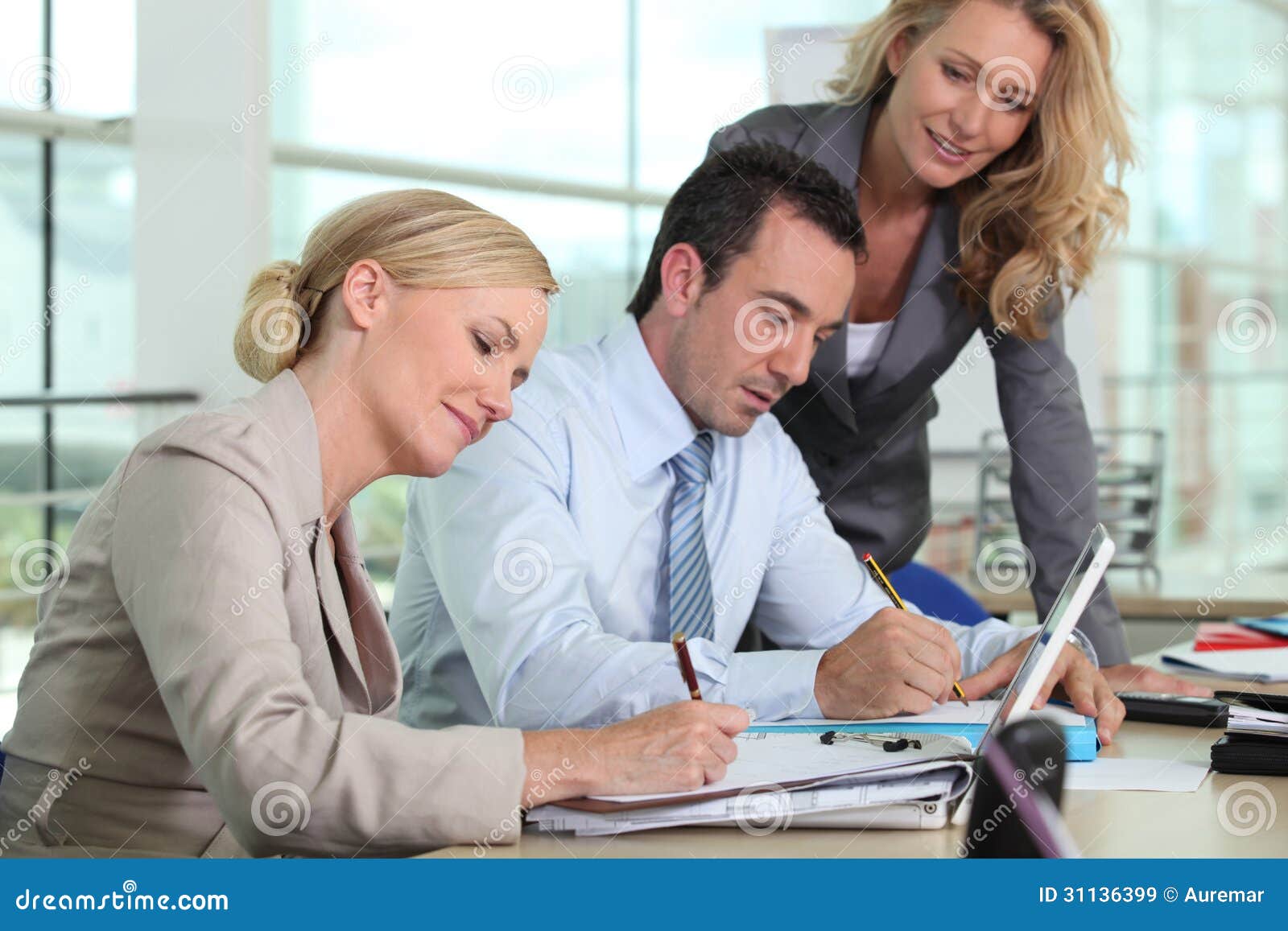 Three Colleagues Working Together Stock Image - Image of pens, comrade ...