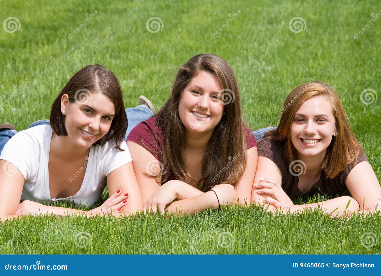 Three College Students Standing In Corridor And Using Tablet And ...