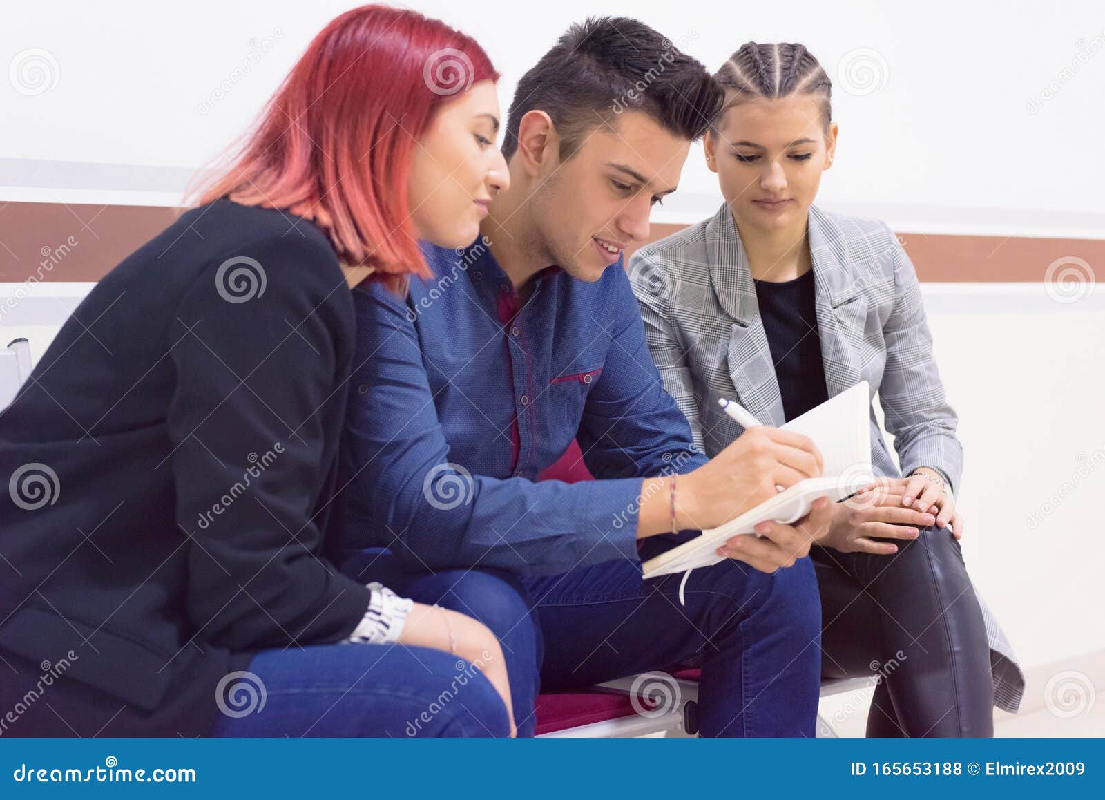 Three College Students Sitting and Using Laptop and Chatting after ...
