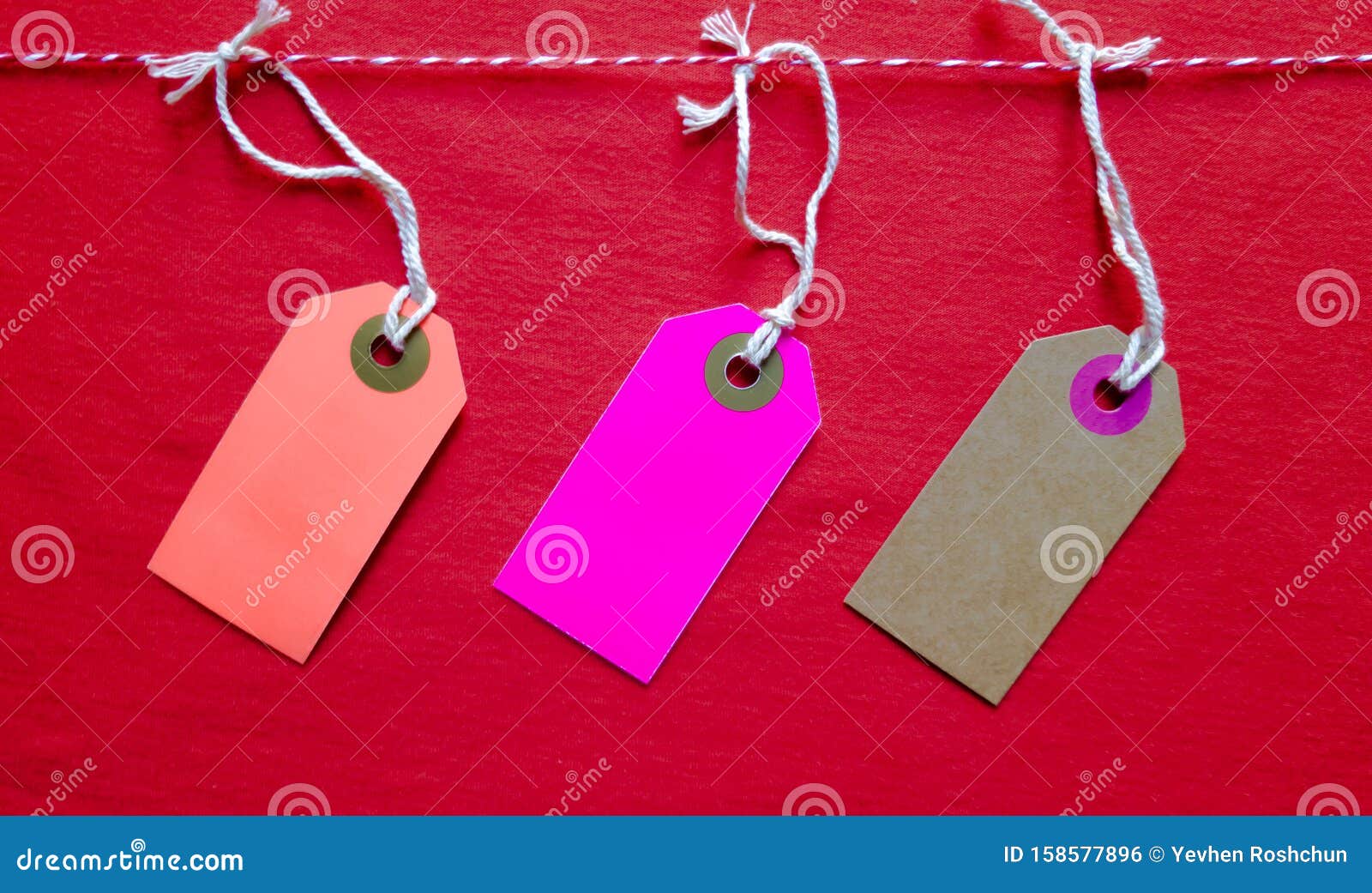 Three Colored Bright Tags Hang on a Red Rope on a Red Background. Copy ...