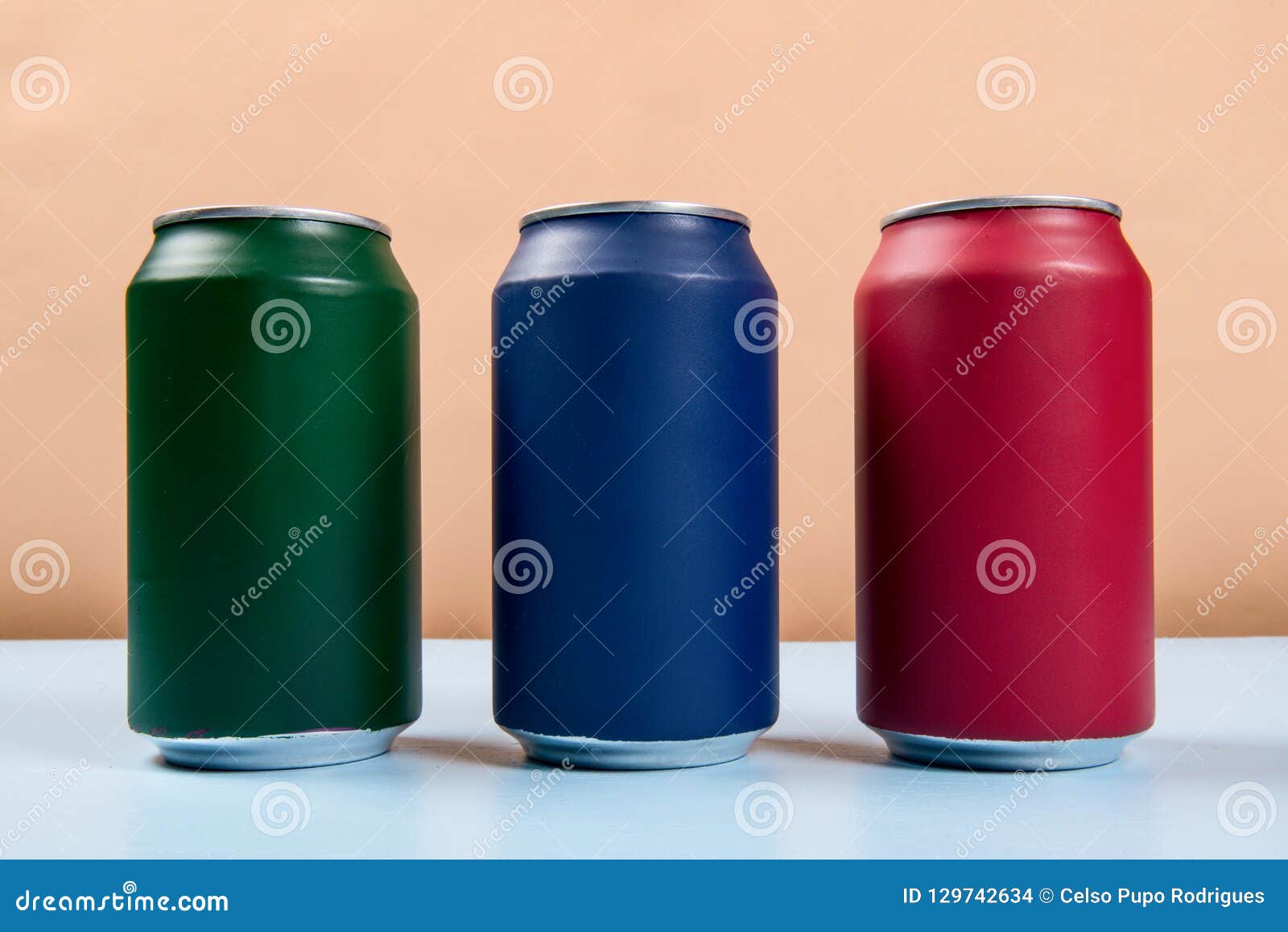 Three Colored Cans Of Soft Drinks Closed On A Light Blue Background ...