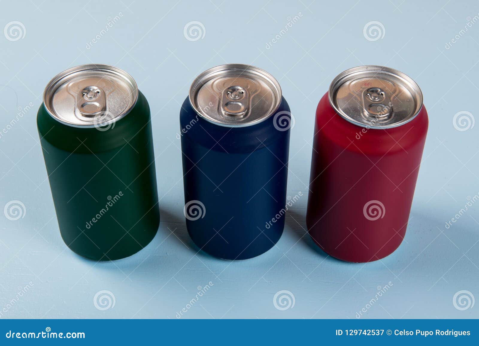 Three Colored Cans of Soft Drinks Closed on a Light Blue Background ...
