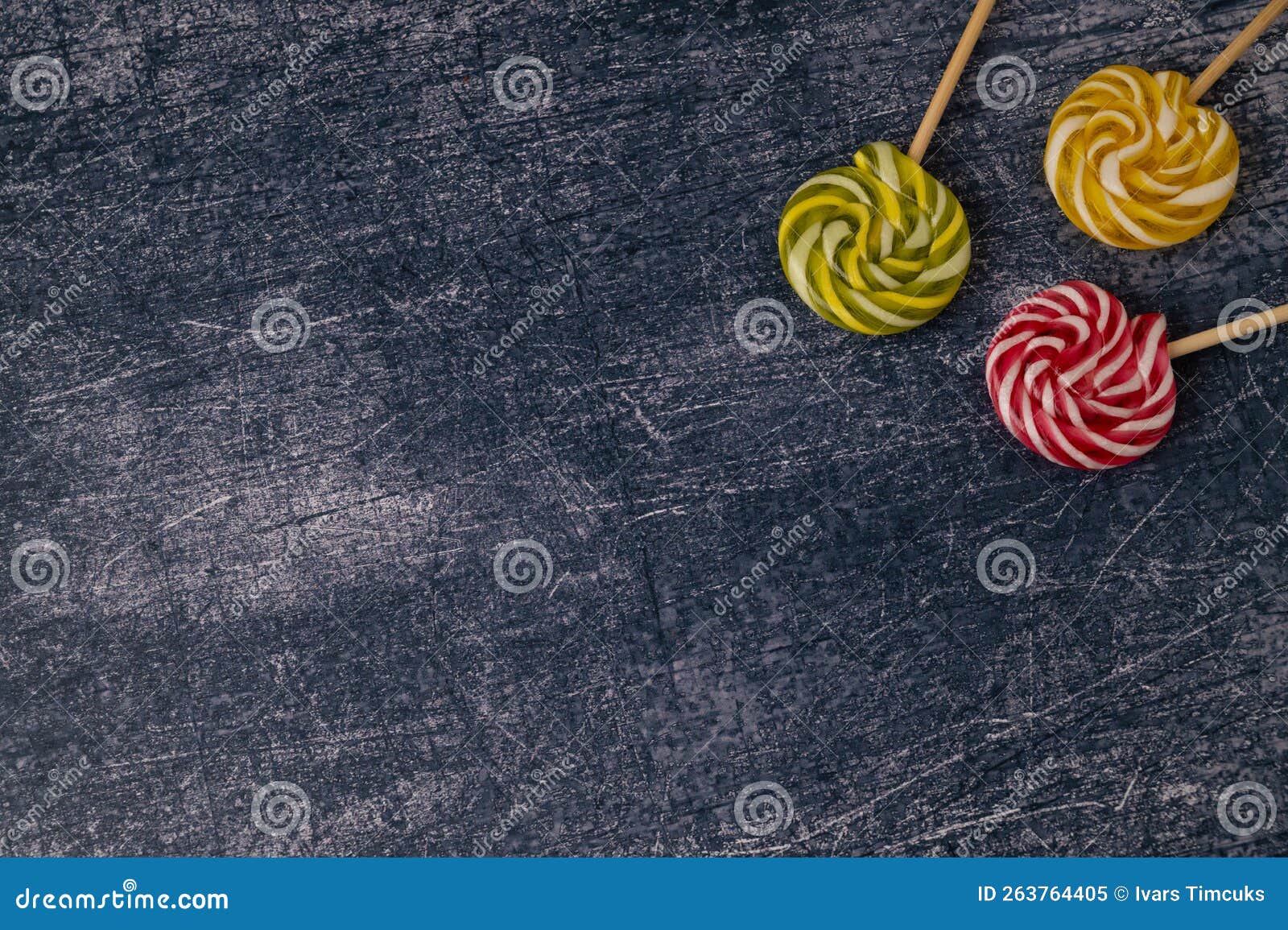 Three Colored Caramels on a Stick in the Upper Corner on a Dark Blue ...