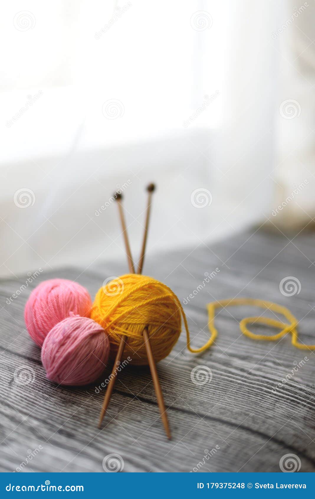 Three Colored Wool Balls, Knitting Needles on the Wooden Background ...