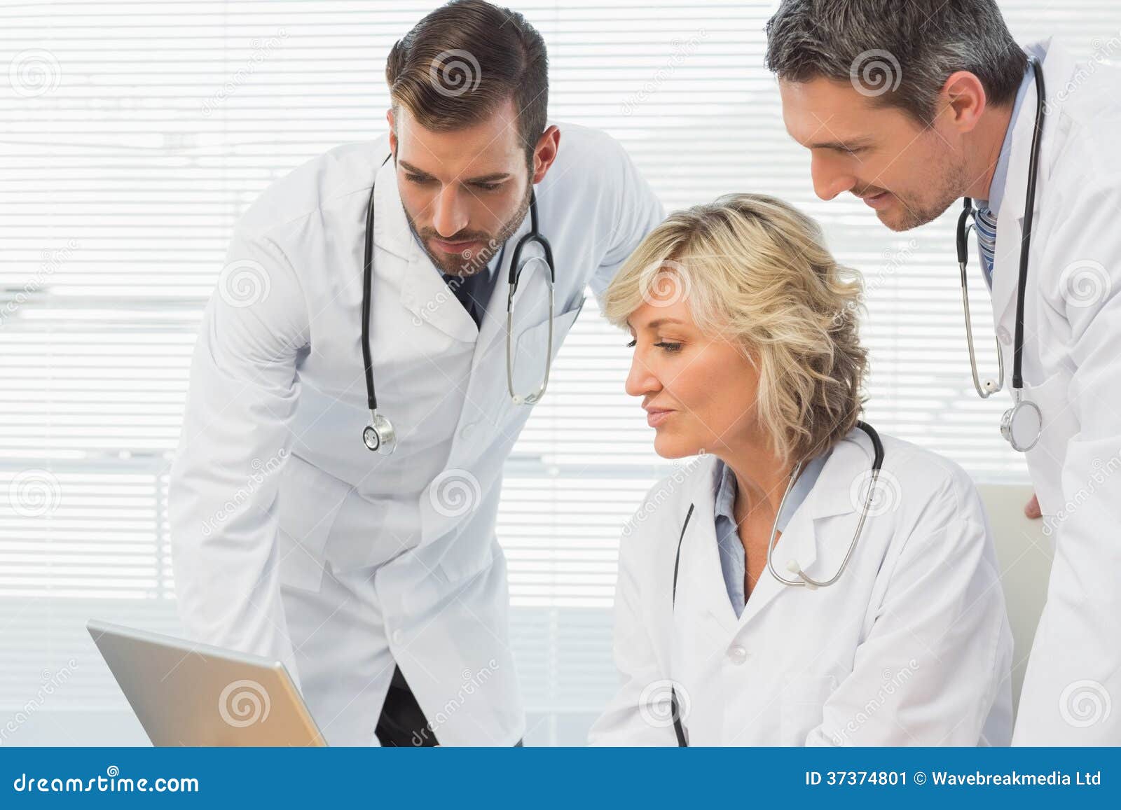 Three Concentrated Doctors Using Laptop Together Stock Image - Image of ...