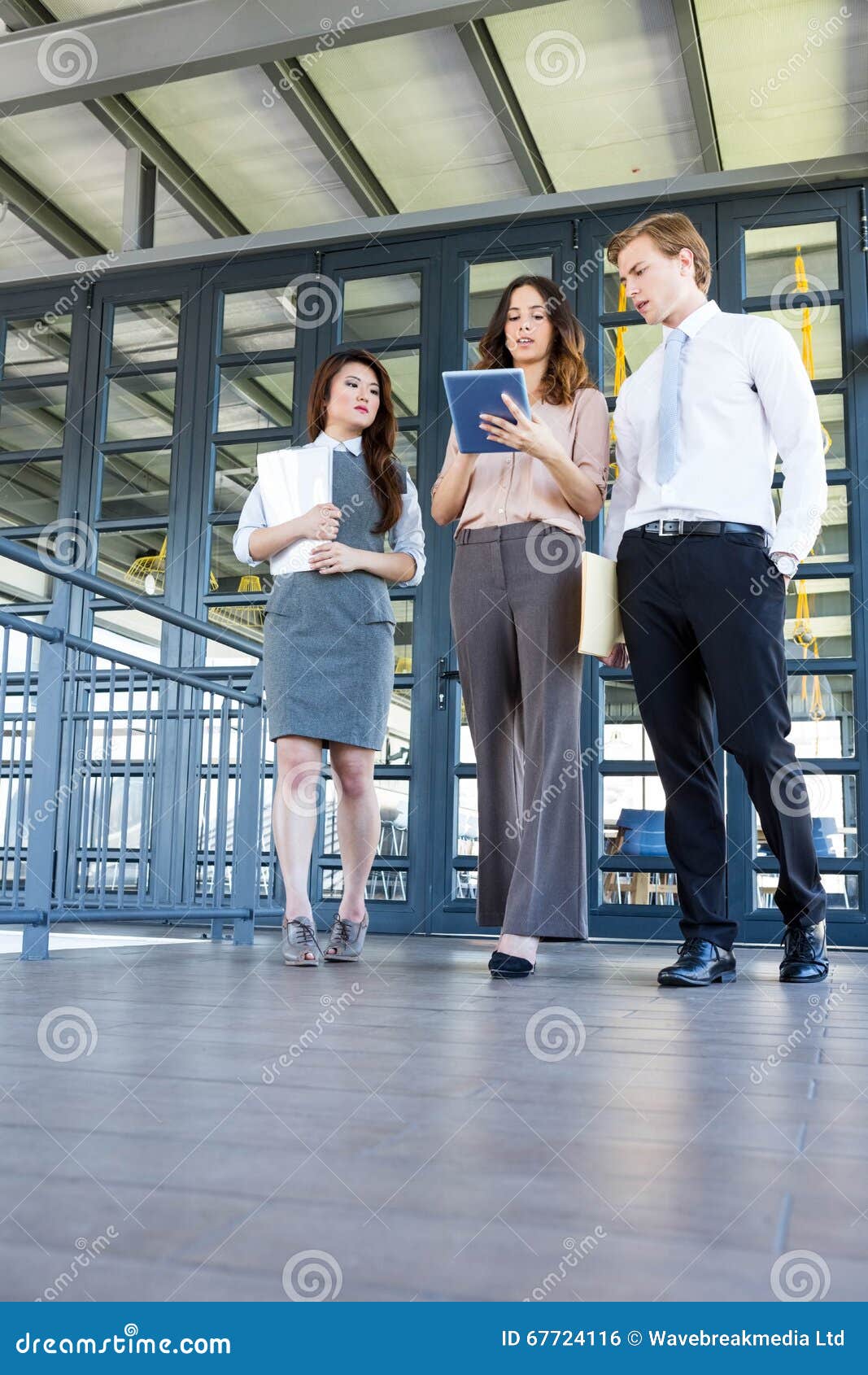 Three Confident Colleagues Discussing in Office Stock Photo - Image of ...
