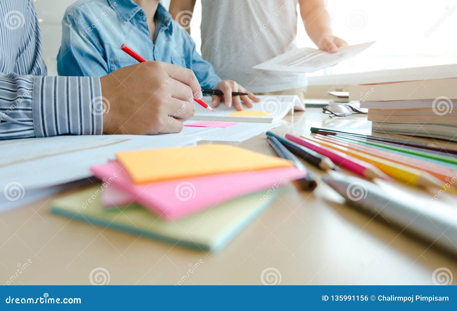 Three Confident Students Doing Homework Together while Sitting at the ...