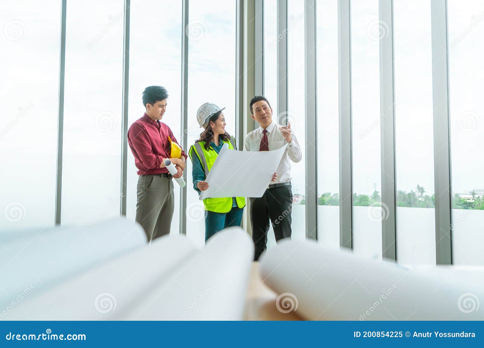 Three Construction Builder Team Looking at Building and Design in ...