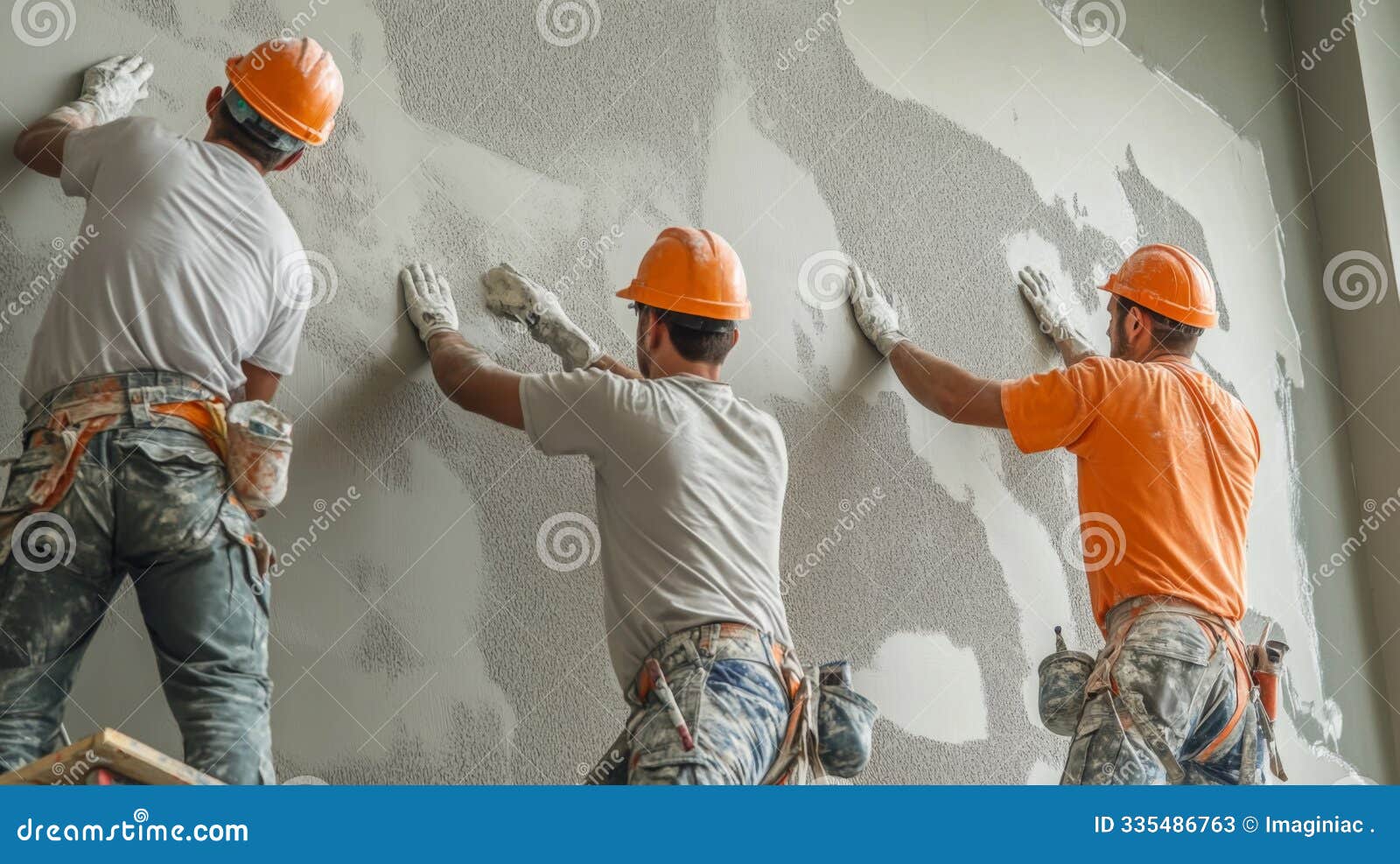 Three Construction Workers Applying Textured Plaster To a Wall Stock ...