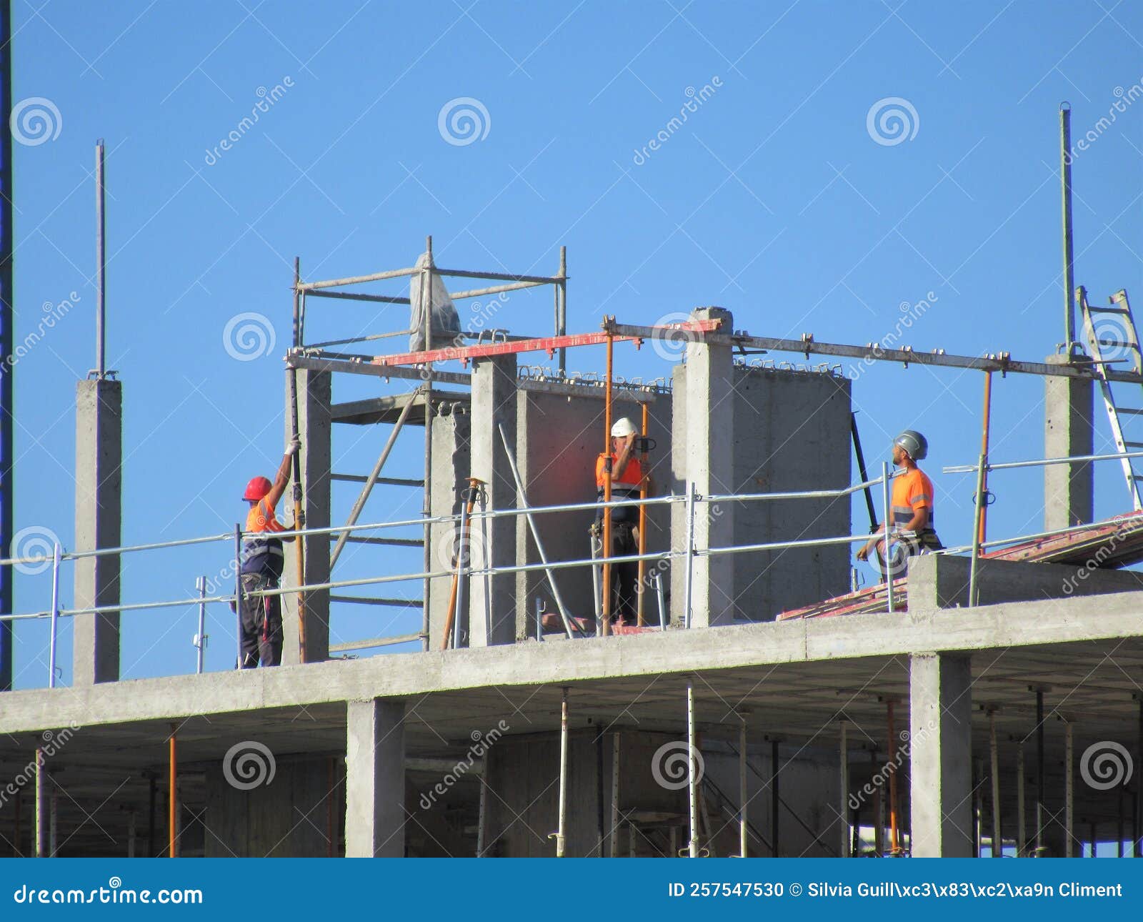 Three Construction Workers Working on a Construction Site. Bricklayer ...