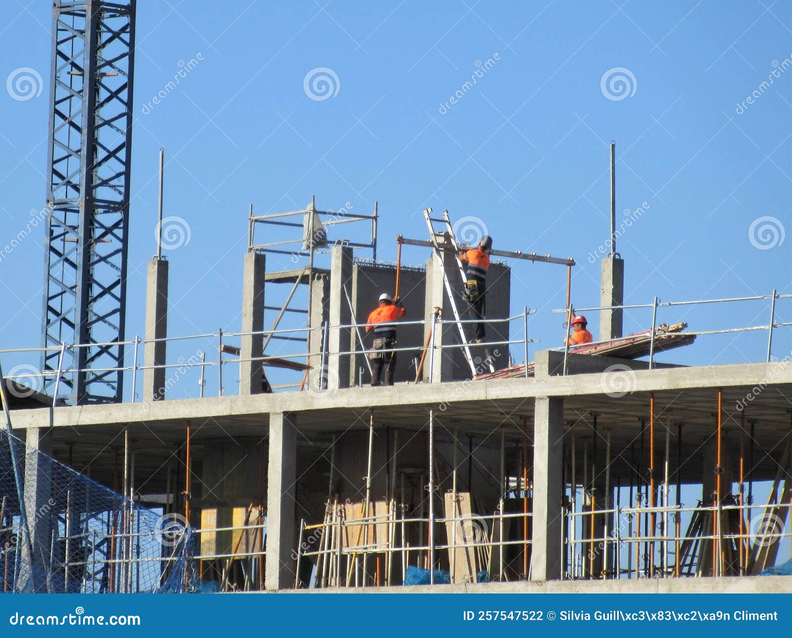 Three Construction Workers Working on a Construction Site. Bricklayers ...