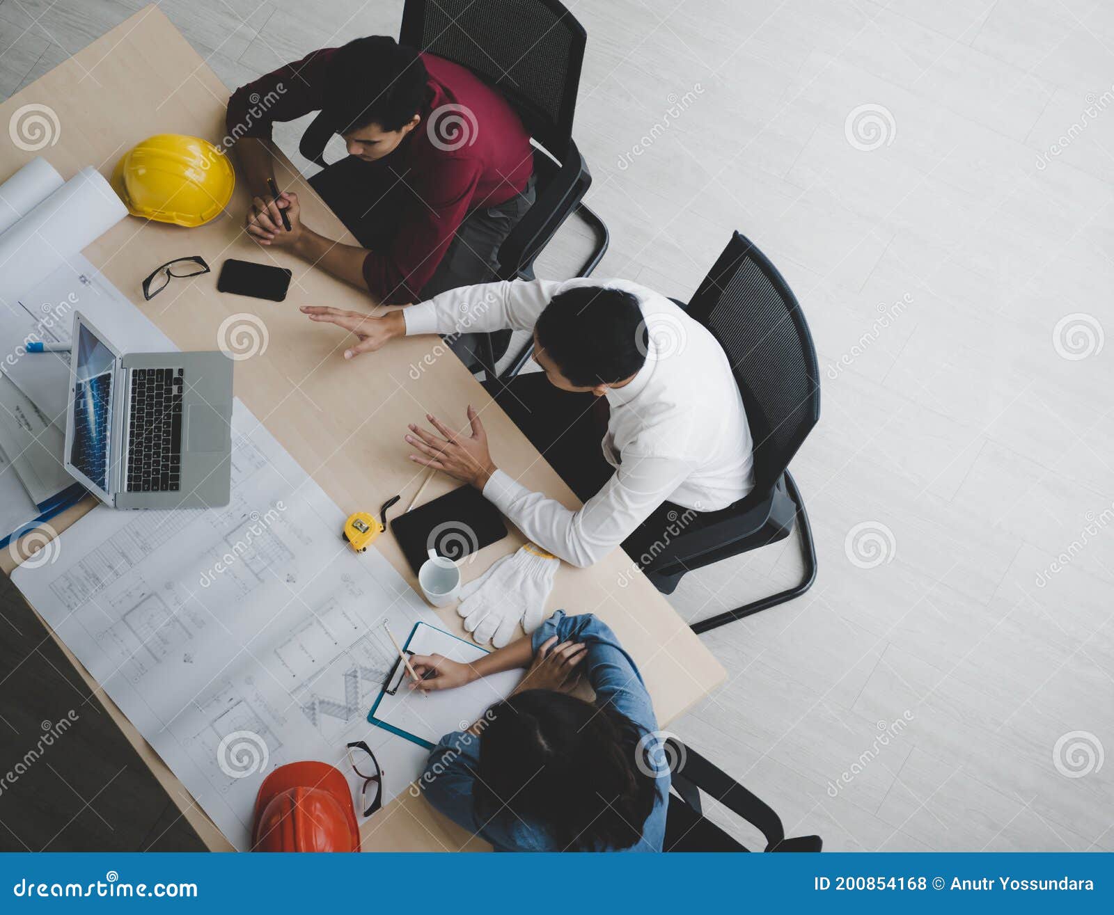 Three Contractor Team Brainstorming On Building Plan At The Far End Of ...