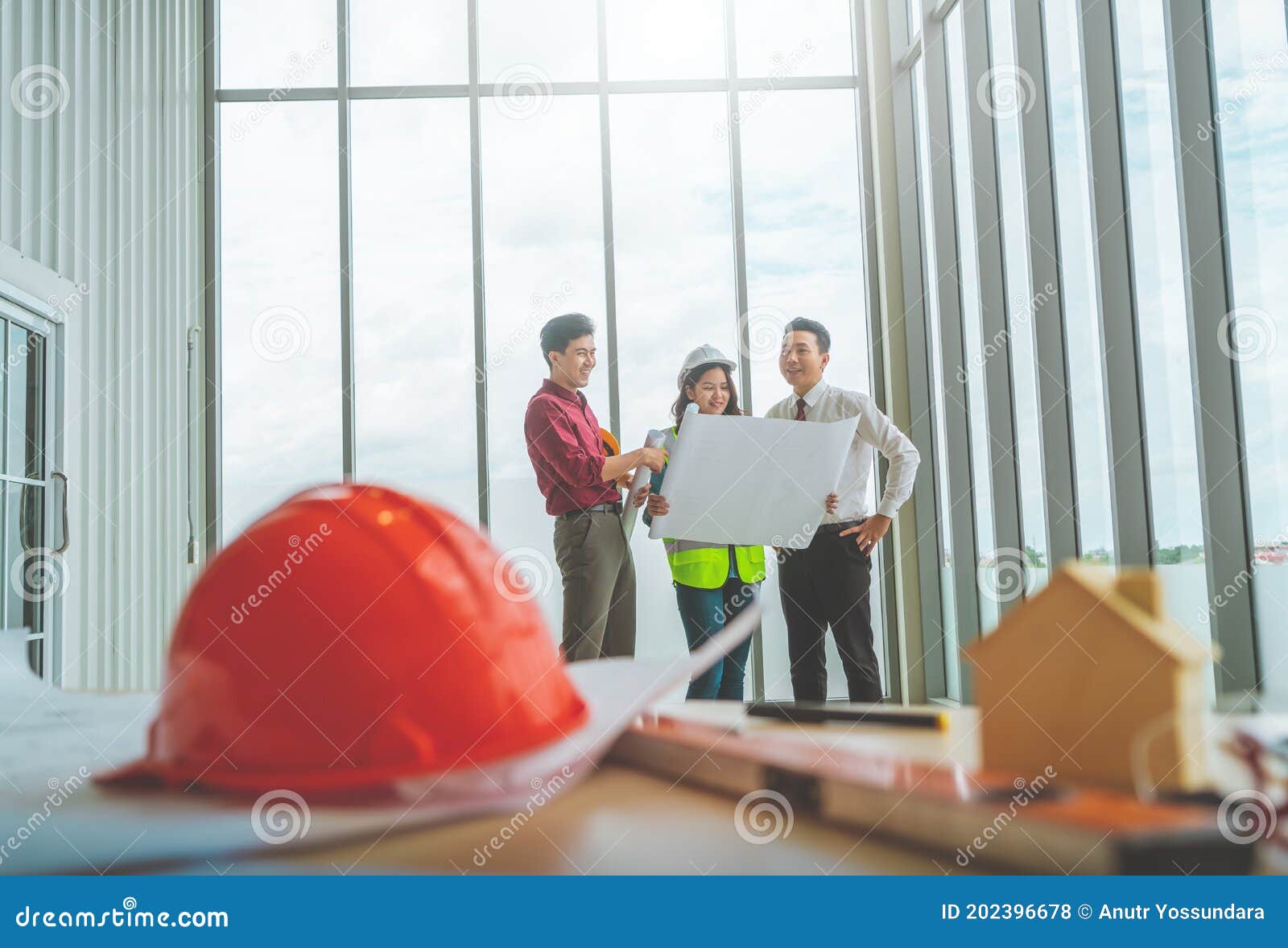 Three Contractor Team Brainstorming on Building Plan at the Far End of ...