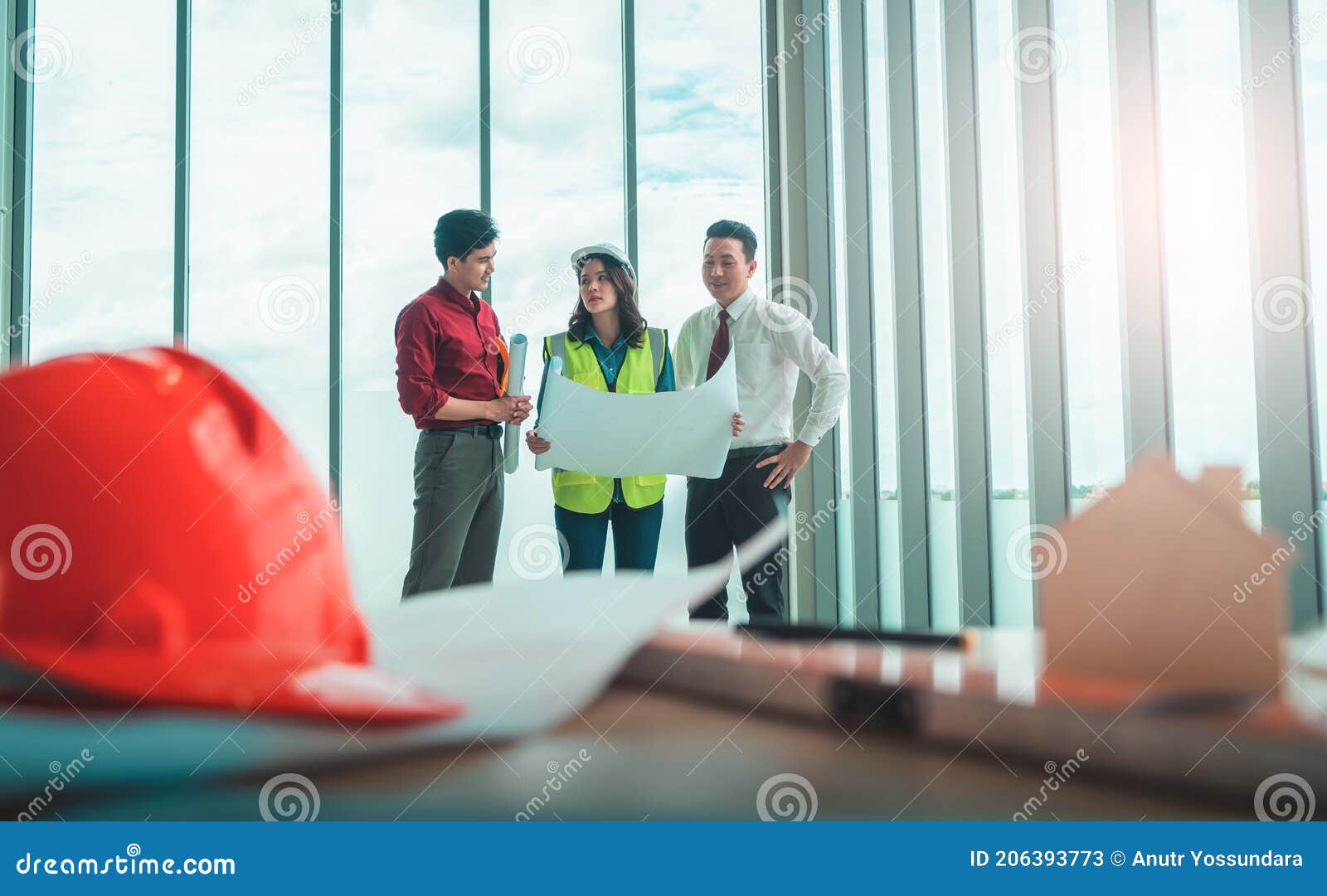 Three Contractor Team Brainstorming On Building Plan At The Far End Of ...