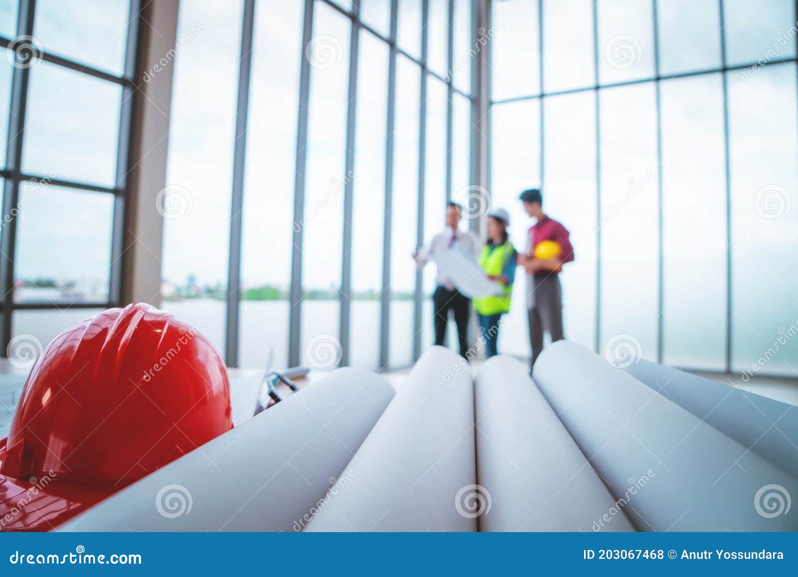 Three Contractor Team Discussing at the Far End of Engineer Table with ...
