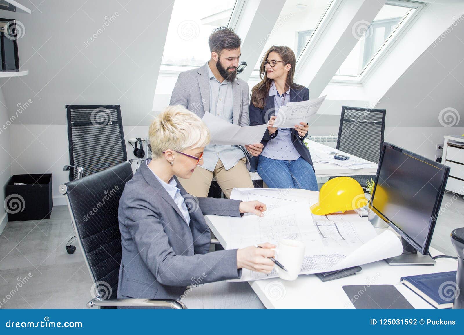Three Cooworkers with Plans on Table Stock Photo - Image of employee ...