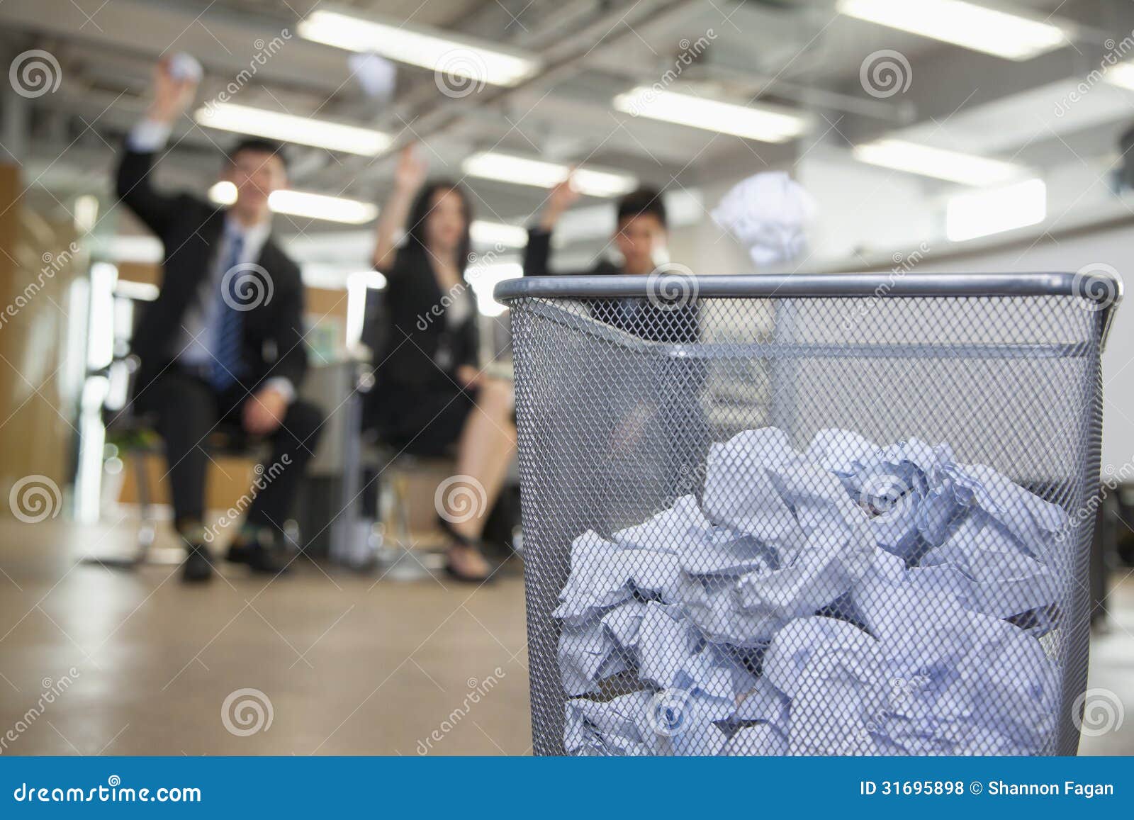 Three Coworkers Preparing To Throw Paper into Waste Basket Stock Photo ...