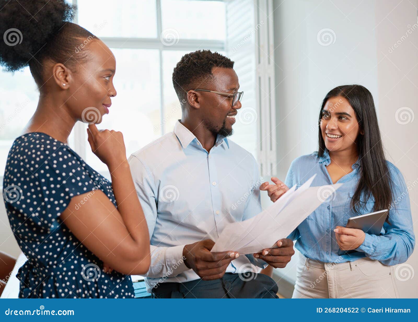 Three Coworkers Stand and Discuss Workplace Issues with Paper, Tablet ...