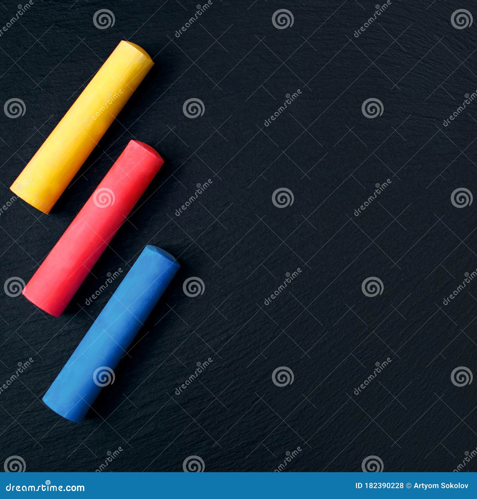 Three Crayons on a Black Textured Blackboard, Yellow, Red and Blue ...