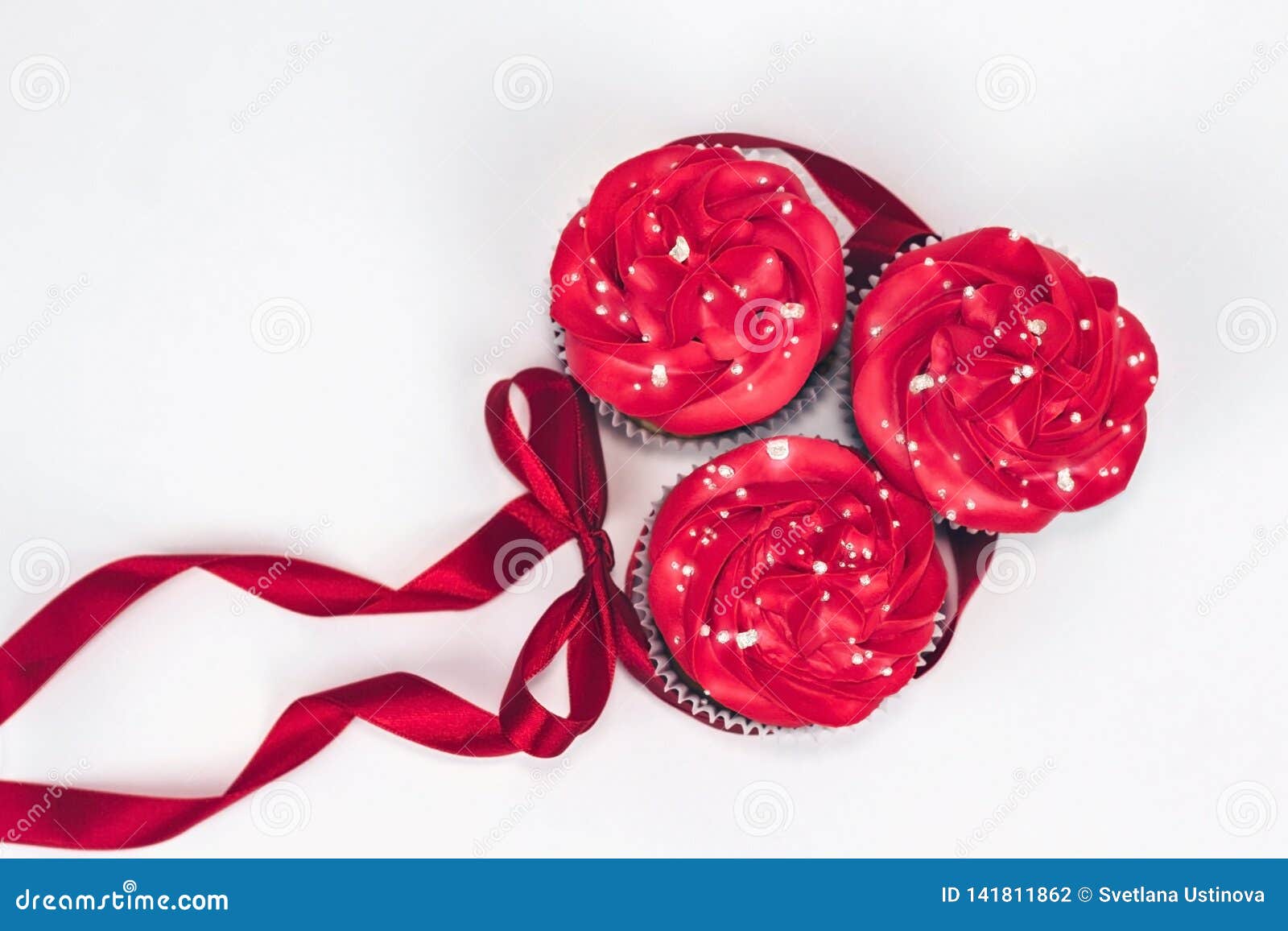 Three Cupcakes with Red Icing Decorated with Red Ribbon with a Bow on ...