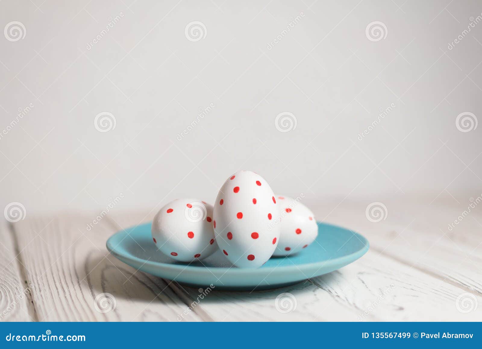 Three Decorated Easter Eggs on a Turquoise Plate on a White Background ...
