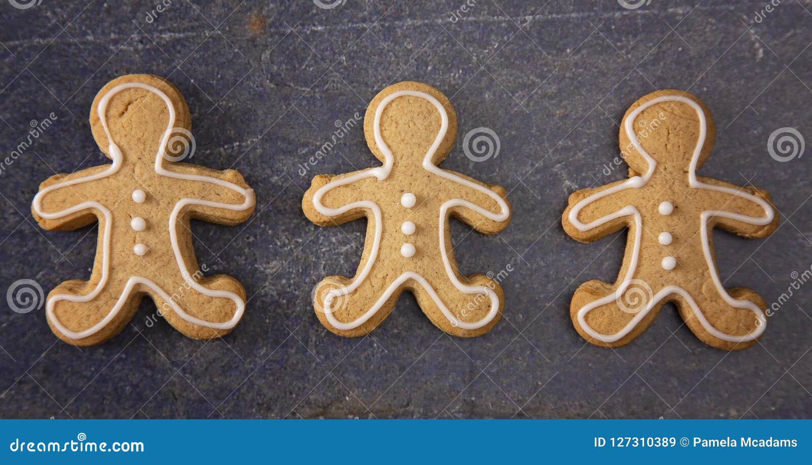 Three Decorated Gingerbread Men on a Dark Surface Stock Image - Image ...