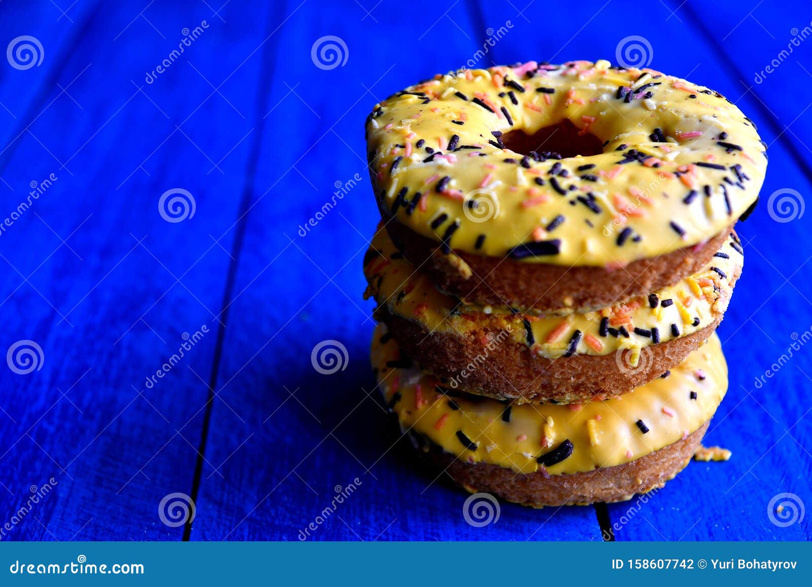 Three Delicious Donuts Folded in a Pyramid on a Table of Painted Blue ...