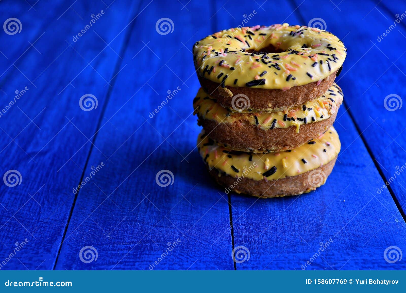 Three Delicious Donuts Folded in a Pyramid on a Table of Painted Blue ...
