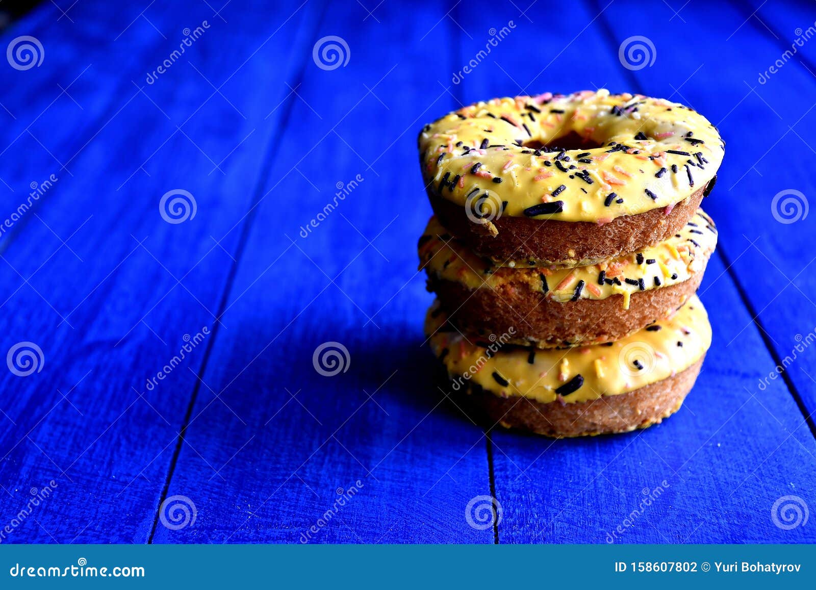 Three Delicious Donuts Folded in a Pyramid on a Table of Painted Blue ...