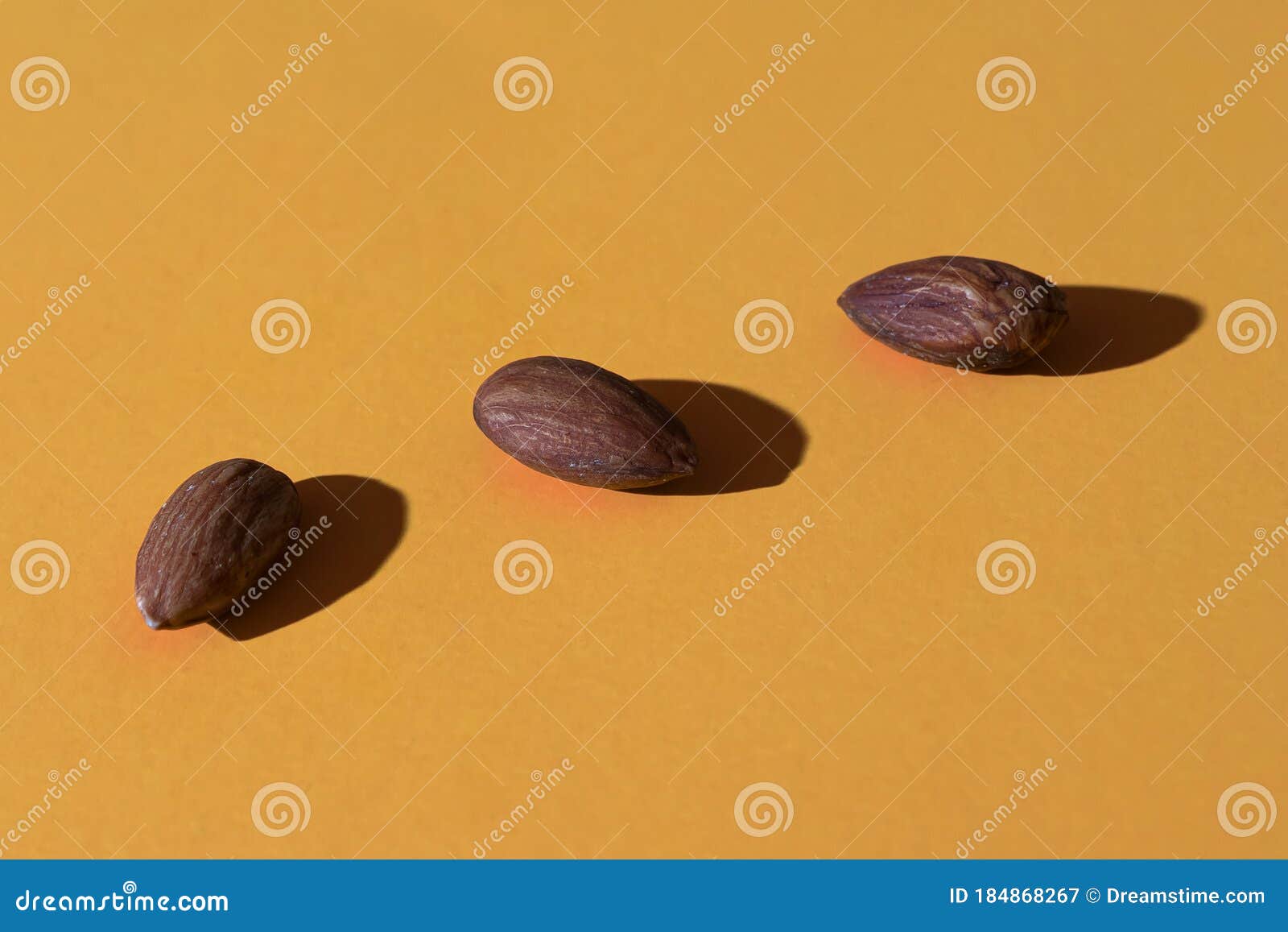 Three Different Almonds on an Orange Colored Background Stock Image ...