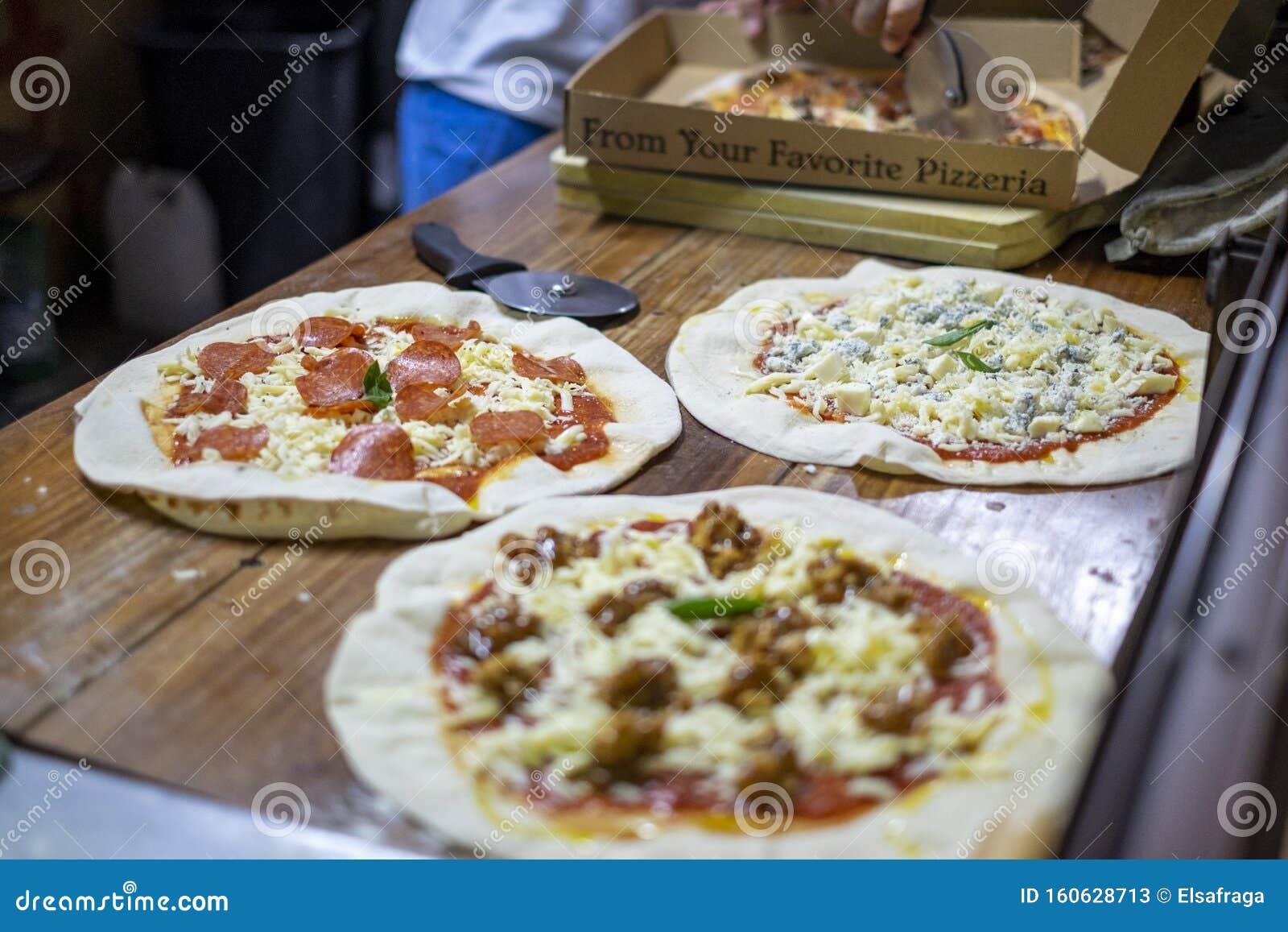 Three Different Pizzas on Display and One in a Box for Take Away Stock ...