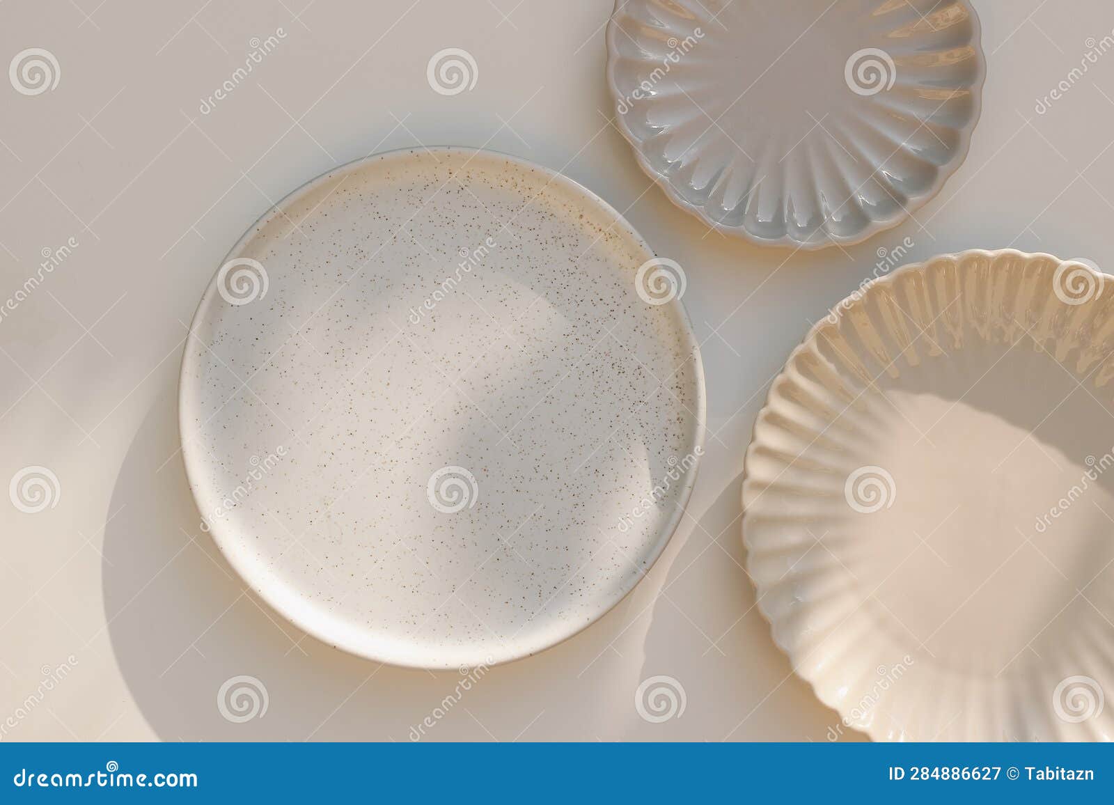 Three Different Size Stoneware Plates on Beige Table Background. Flat ...