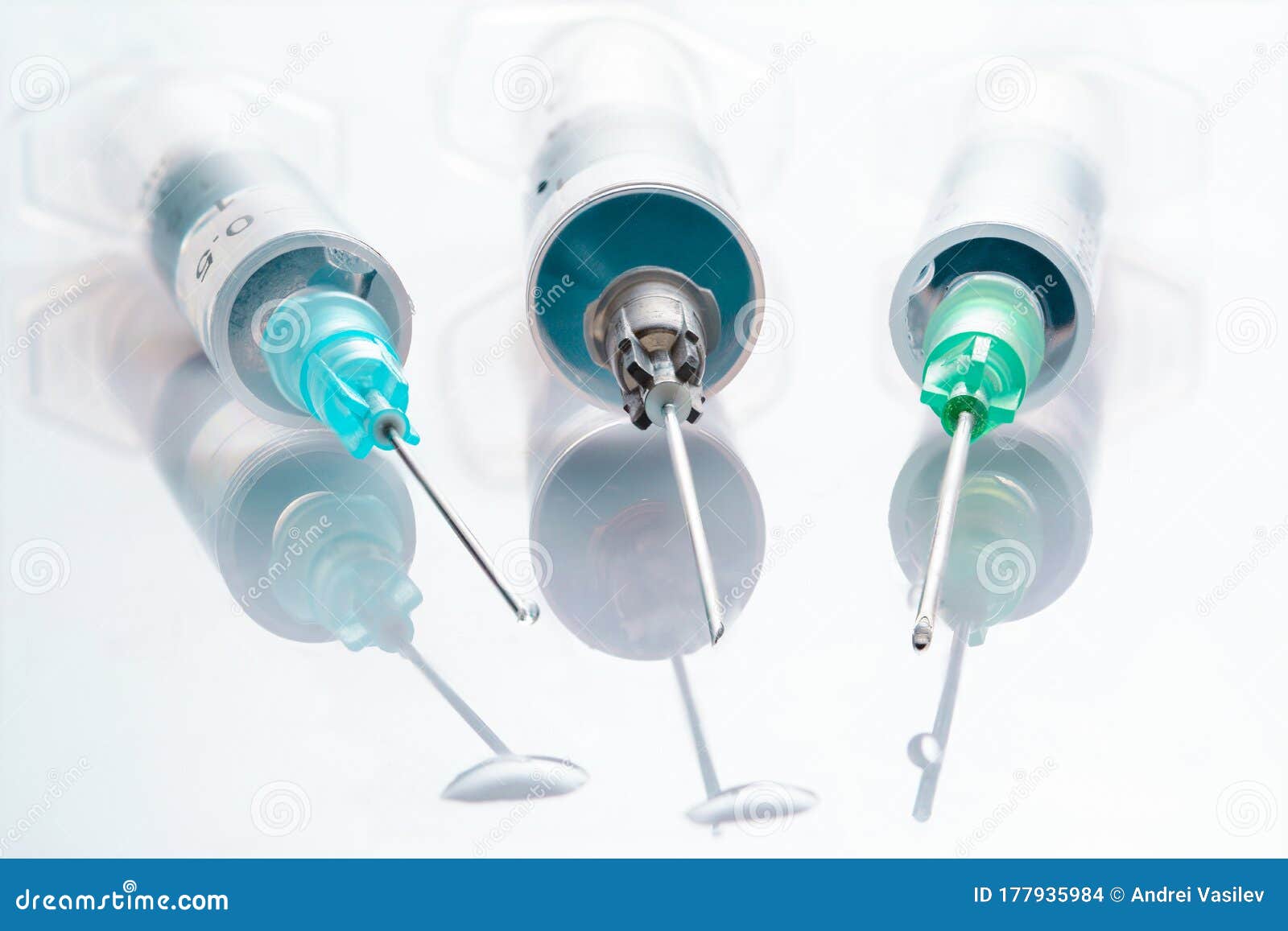 Three Different Syringes with Medicinal Solution, on Light Green ...