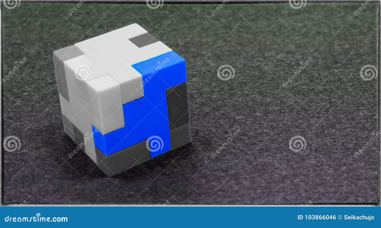 Three Dimensional White, Grey and Blue Cube Puzzle on a Grey Background ...