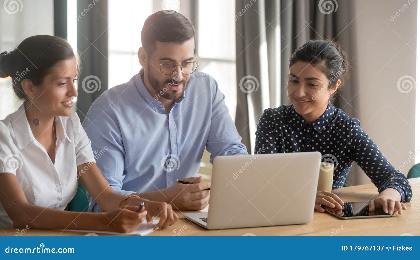 Three Diverse Teammates Looking at Computer Screen Discussing Project ...