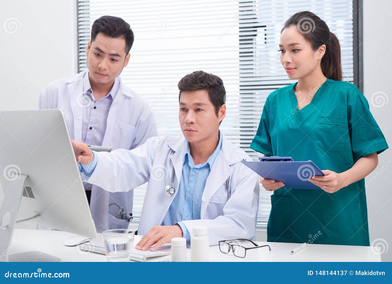 Three Doctors Discussing Patient Files On Office Royalty-Free Stock ...