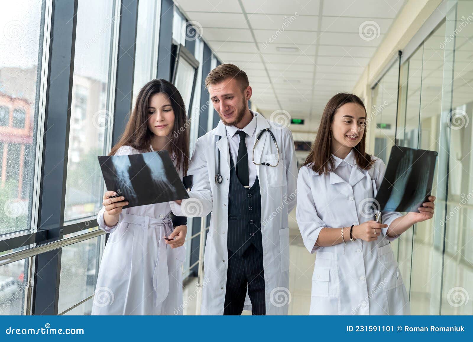 Three Doctors Discussing Scan Results of X-ray Image in Clinic Stock ...