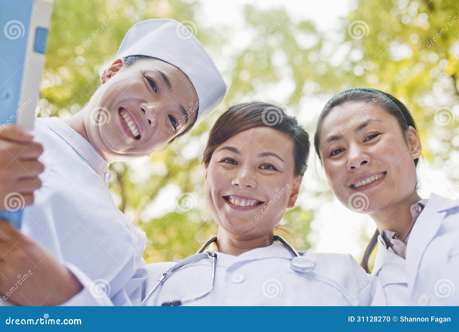 Three Doctors Smiling and Looking Down at Camera Stock Photo - Image of ...