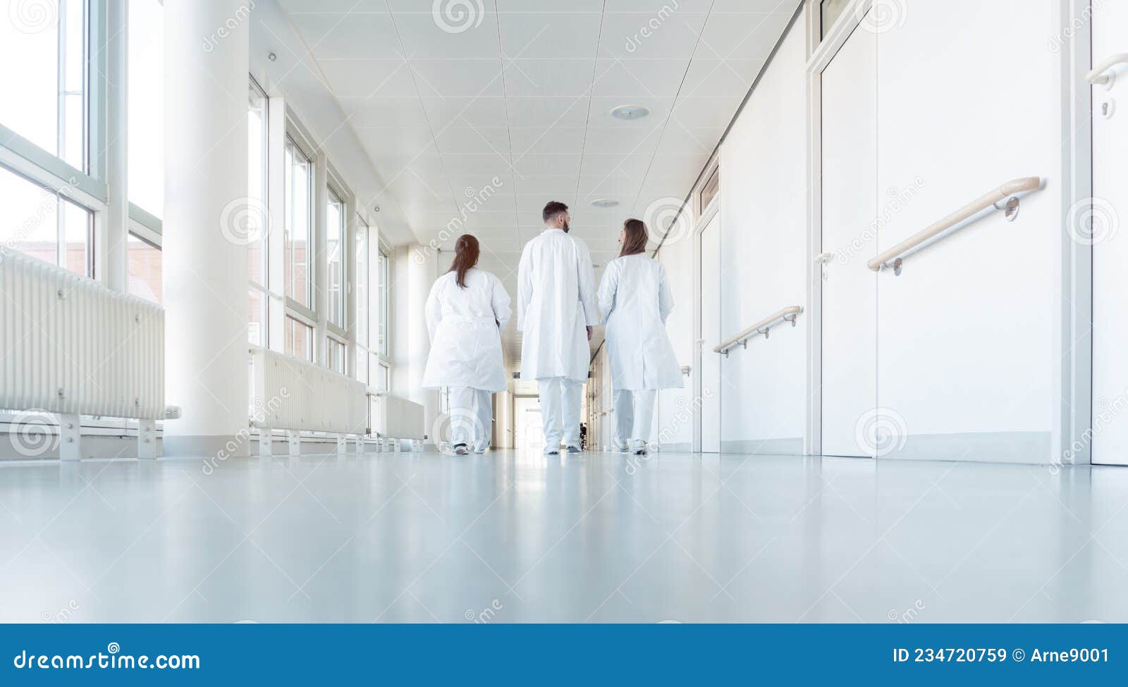 Three Doctors Walking Down a Corridor in Hospital Stock Image - Image ...